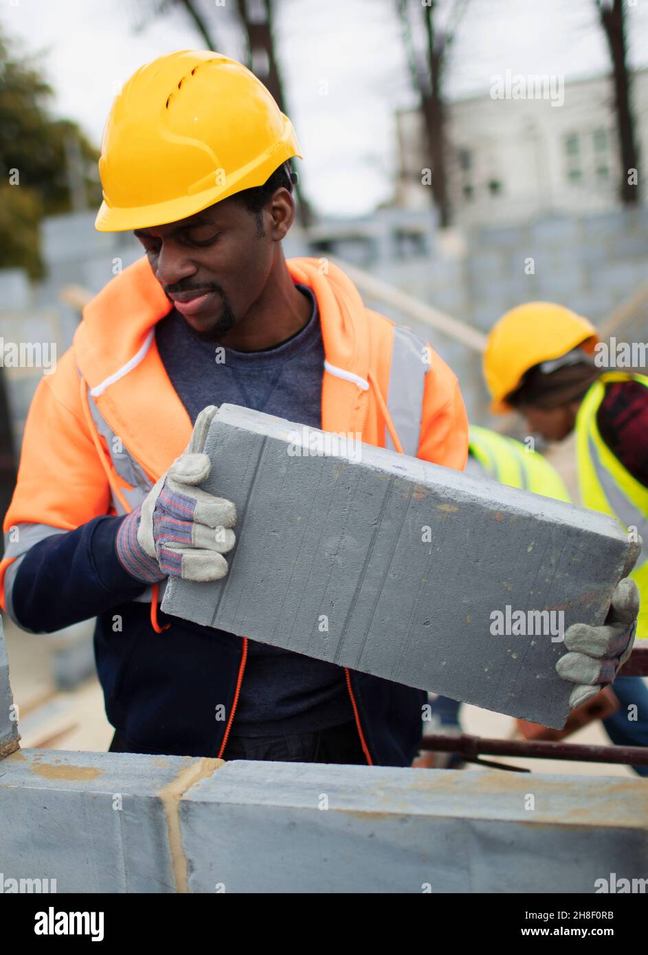 Male construction worker laying cement bricks Stock Photo - Alamy