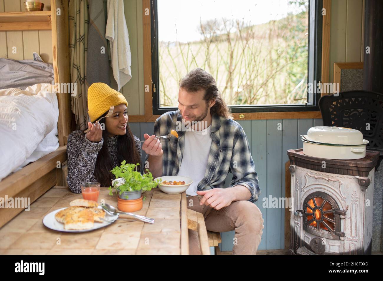 Young couple enjoying lunch in tiny cabin rental Stock Photo - Alamy