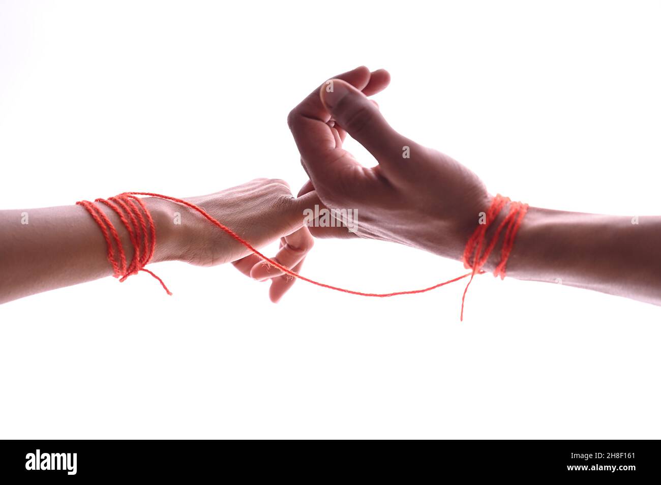 Male and female hands wrapped in red thread isolated on white, concept ...