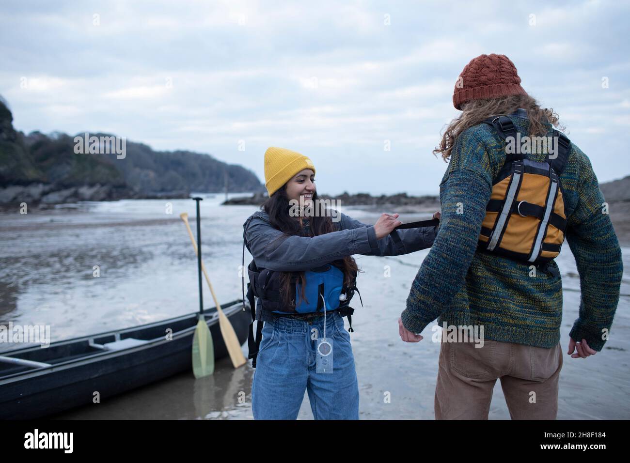 Young couple preparing for canoeing on beach Stock Photo - Alamy