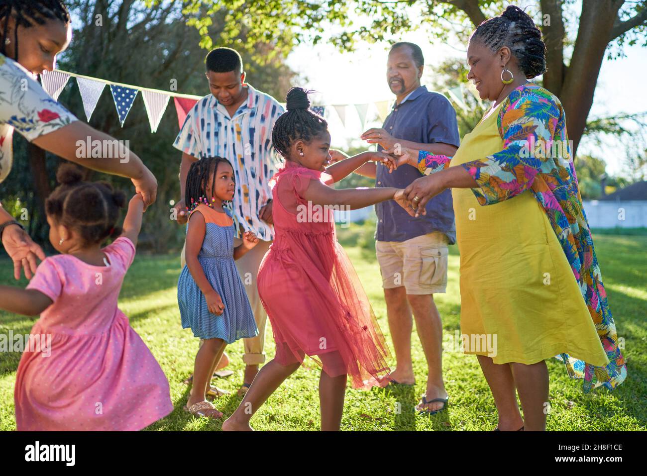 Carefree multigenerational family dancing in summer backyard Stock ...