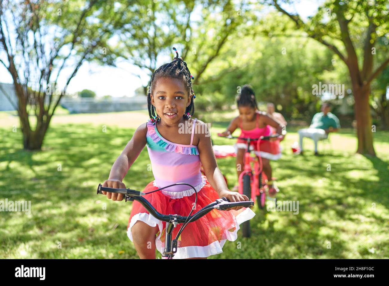 Portrait cute girl riding bicycle in summer park Stock Photo - Alamy