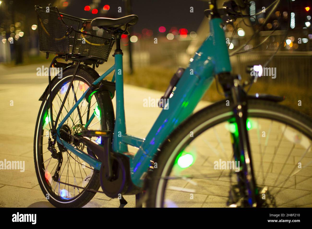 Illuminated bicycle on sidewalk at night Stock Photo - Alamy