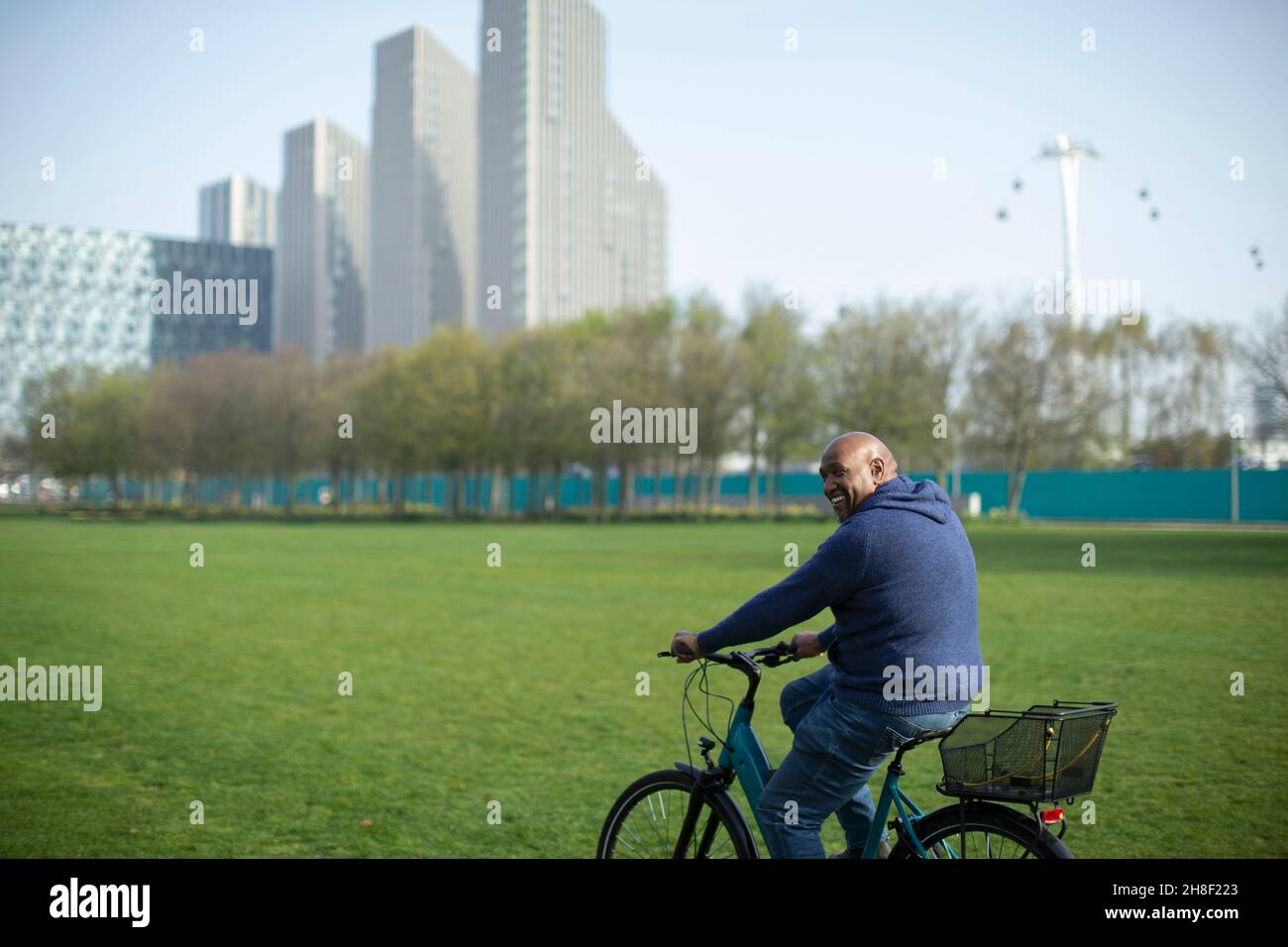 Happy man riding bicycle in urban park grass Stock Photo - Alamy