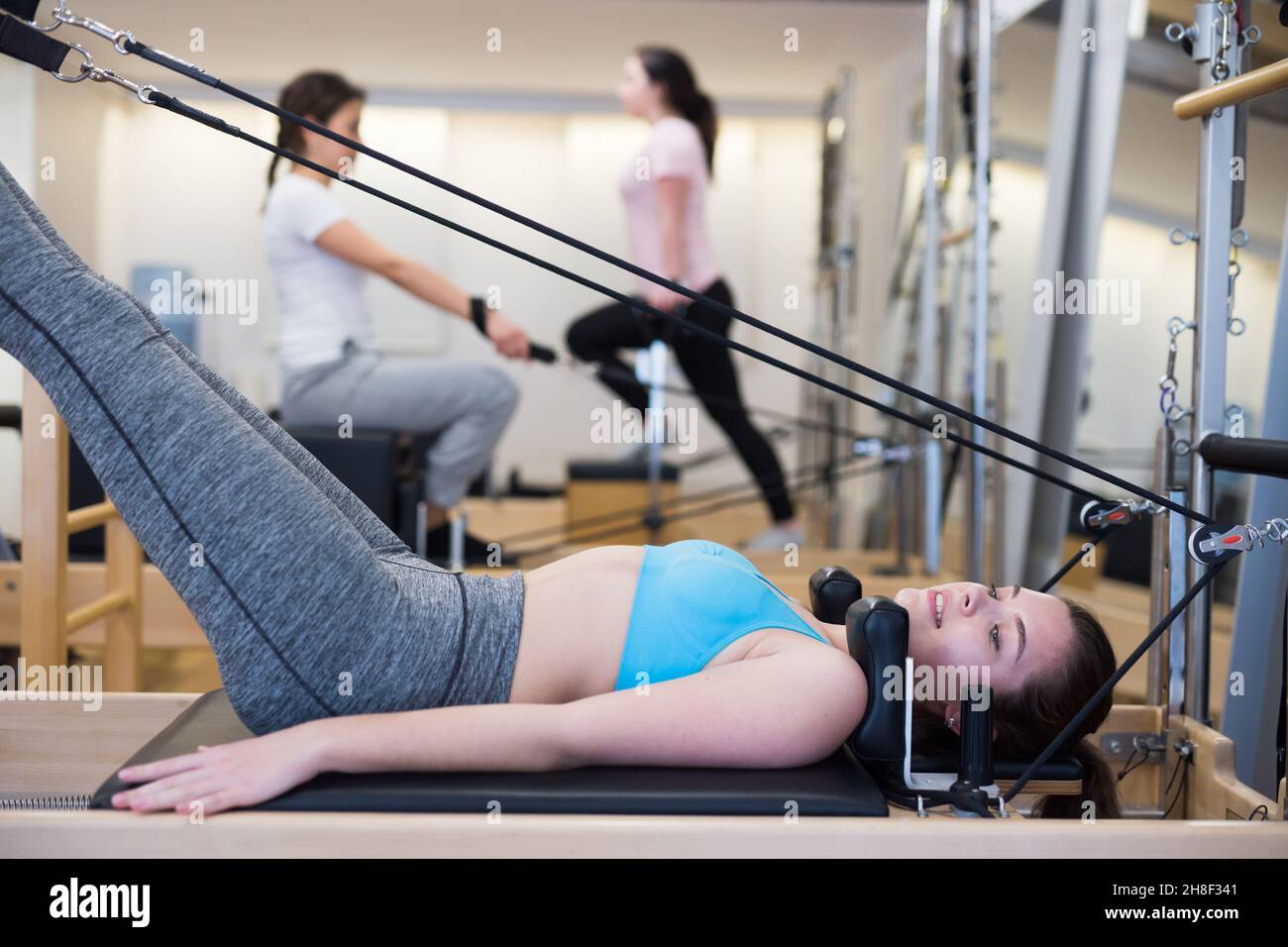 Woman exercising torson rotation at gym using pilates beds Stock Photo ...