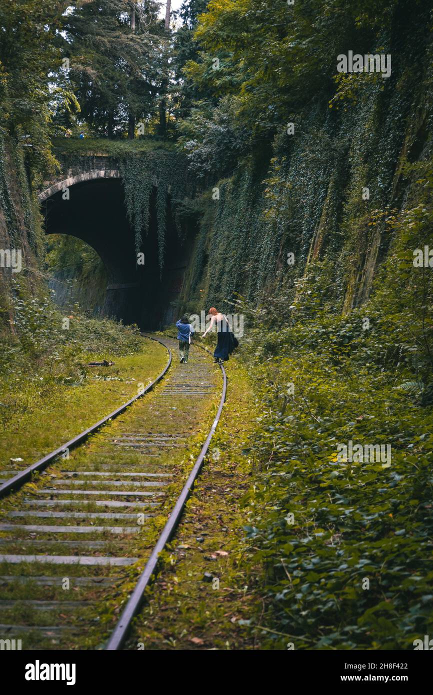 Vertical shot of people walking on a railway Stock Photo - Alamy