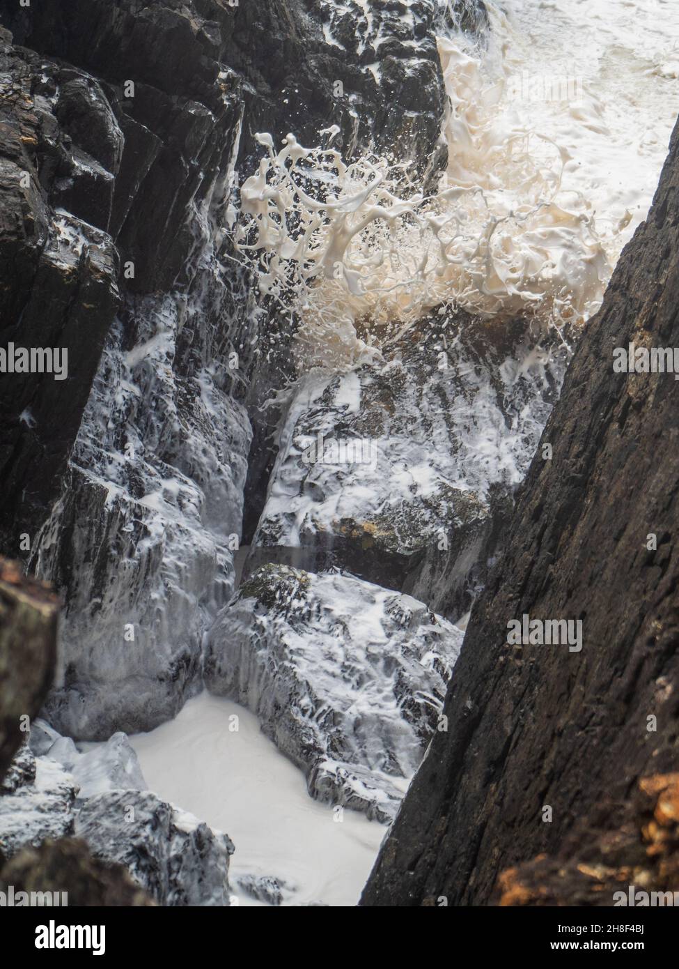 Force of nature. Creamy white foam, froth from sea water smashing into ...