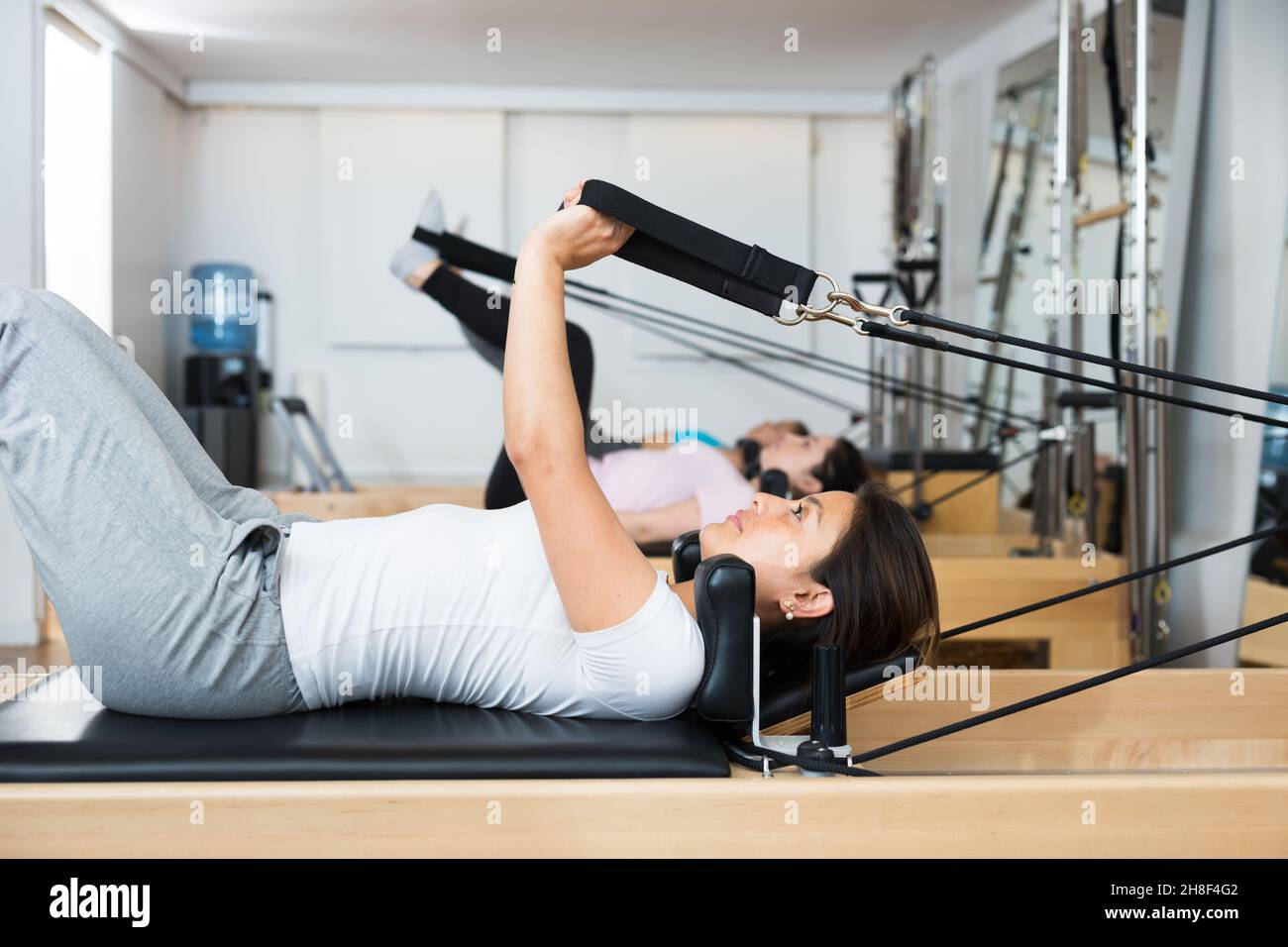 Women doing pilates exercises lying on pilates machines Stock Photo - Alamy
