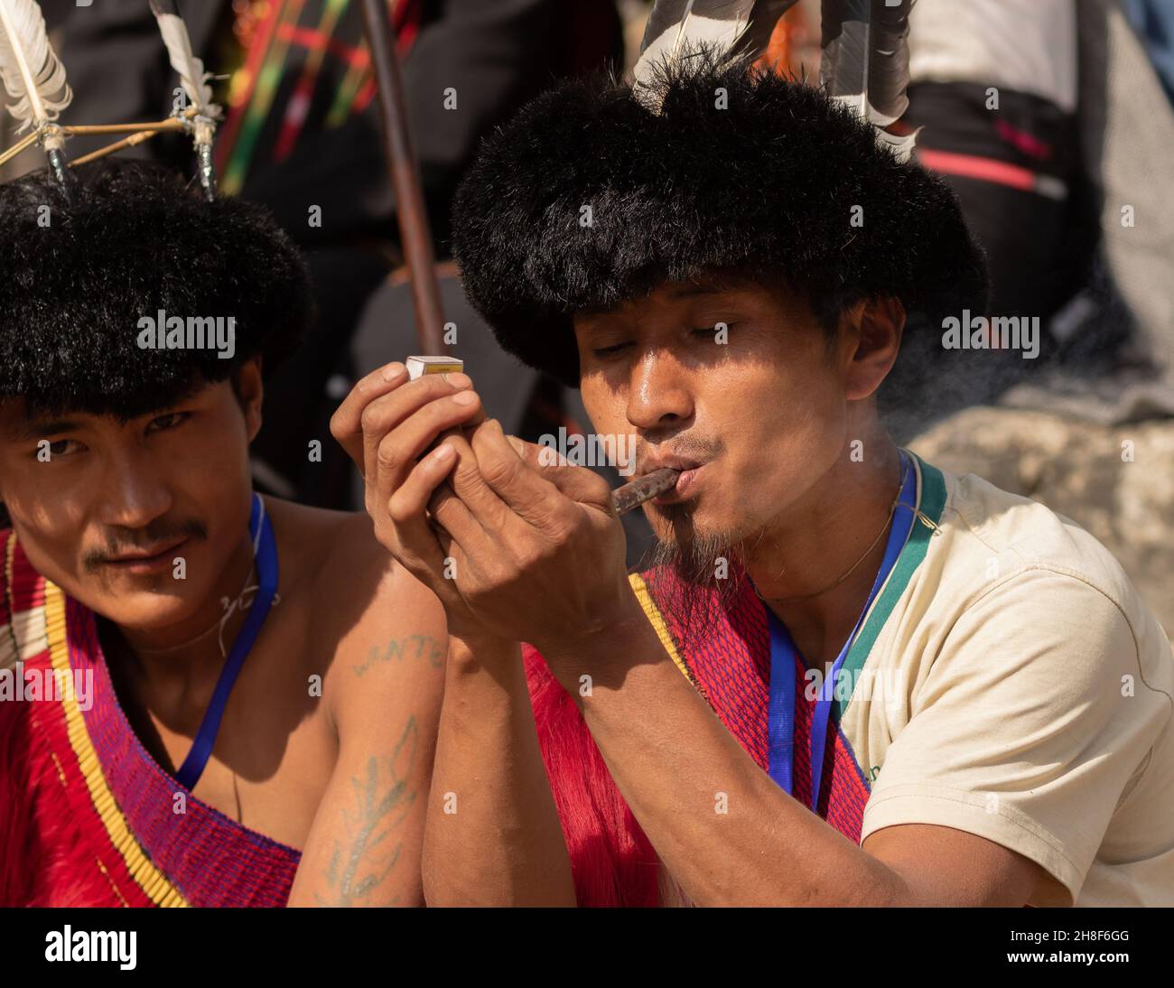 Portrait of a Naga Tribesman dressed in tribal Attire smoking a pipe ...