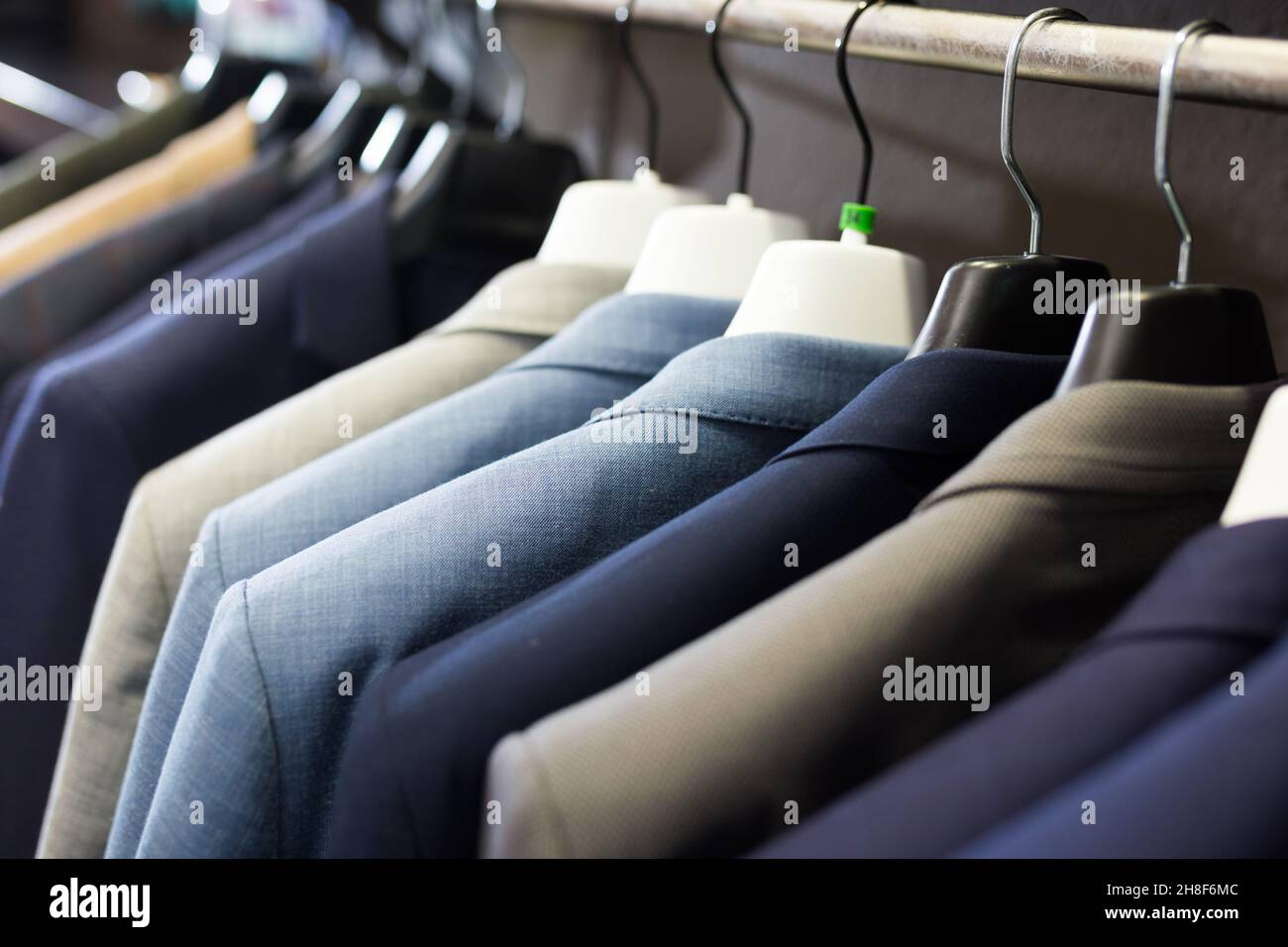 Men suits on hanger racks in shop Stock Photo - Alamy