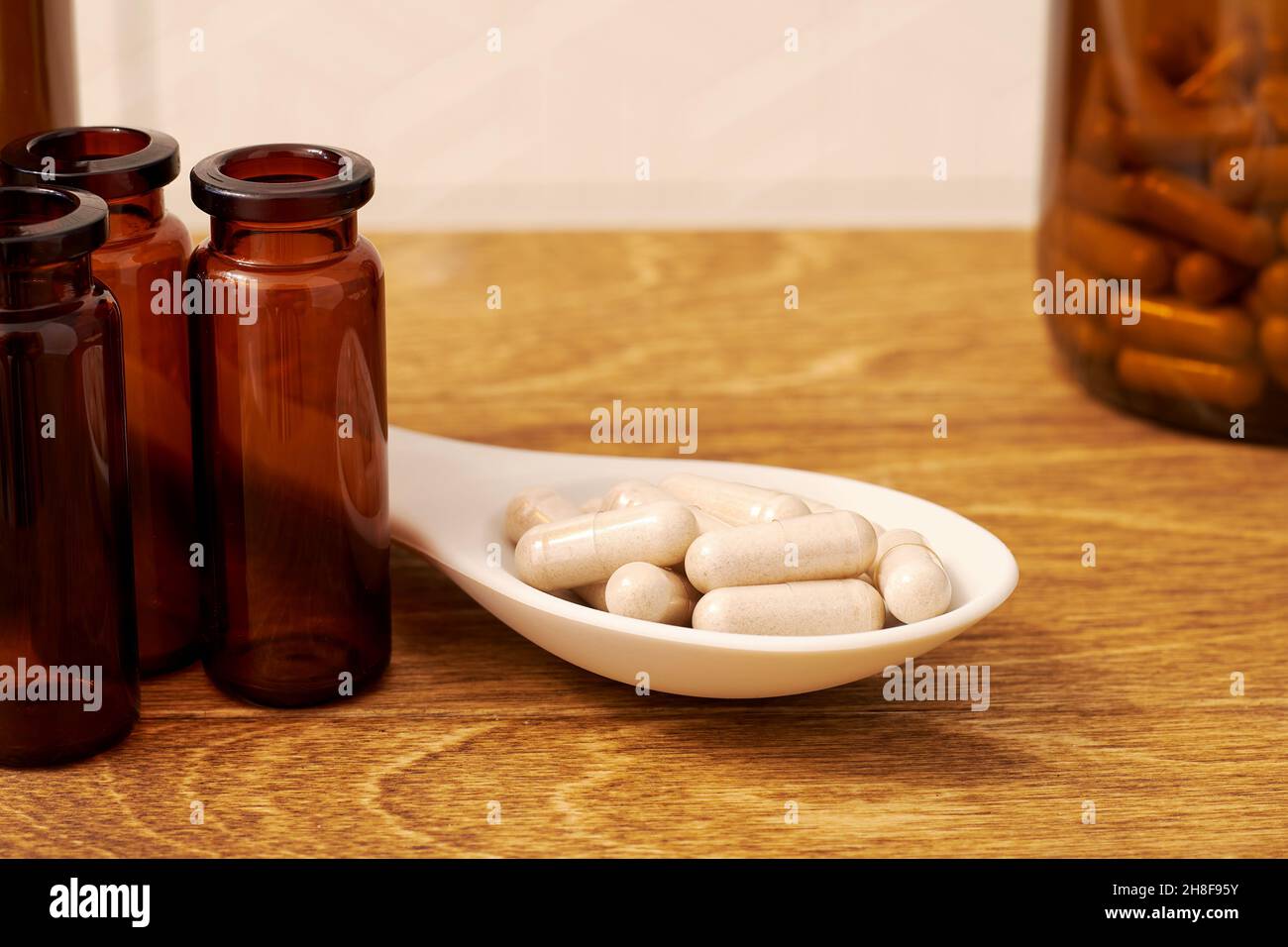 Spoon with a number of medical capsules with a powder inside. Empty ...