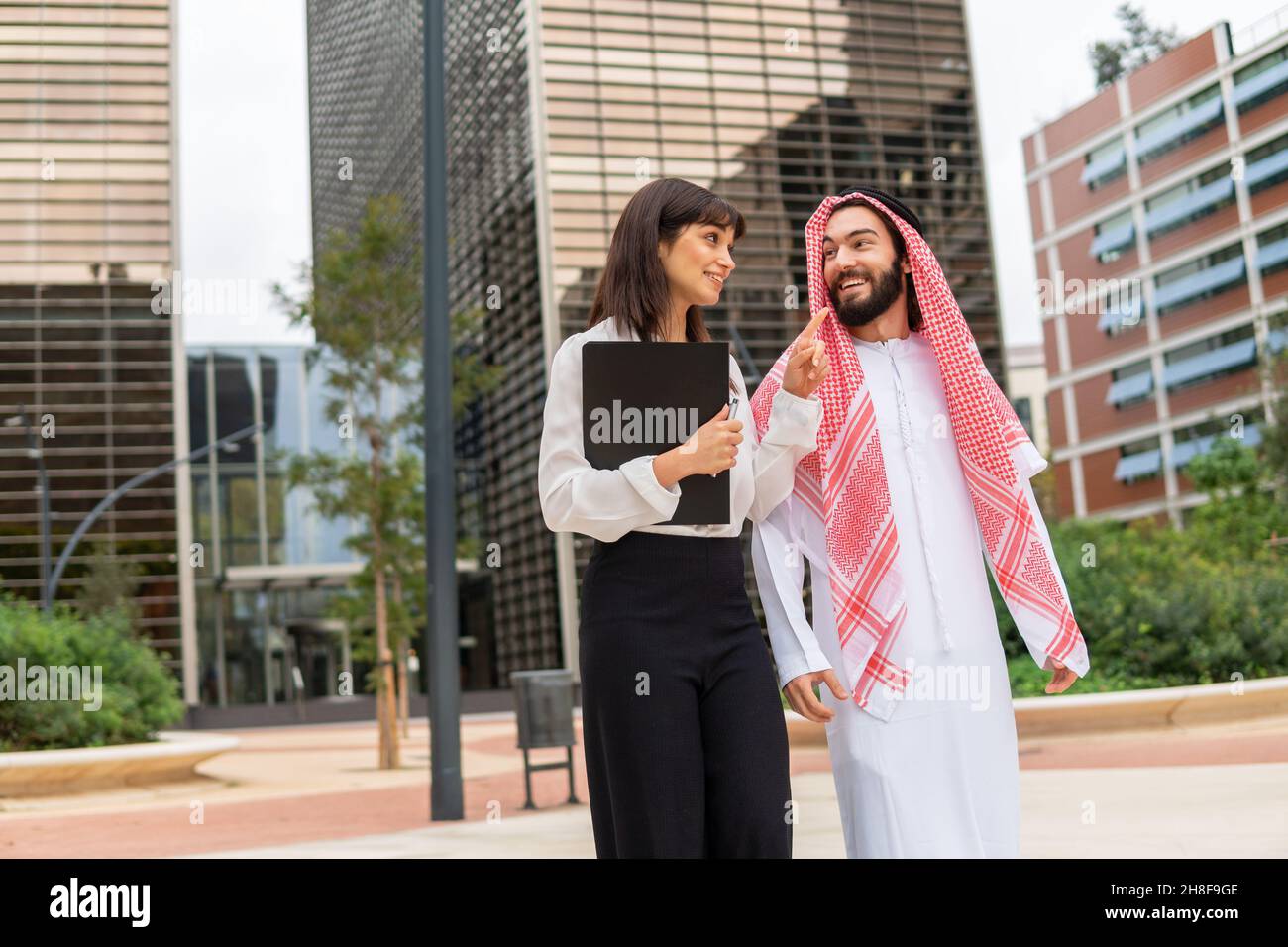From below positive female manager gesturing and smiling while walking ...
