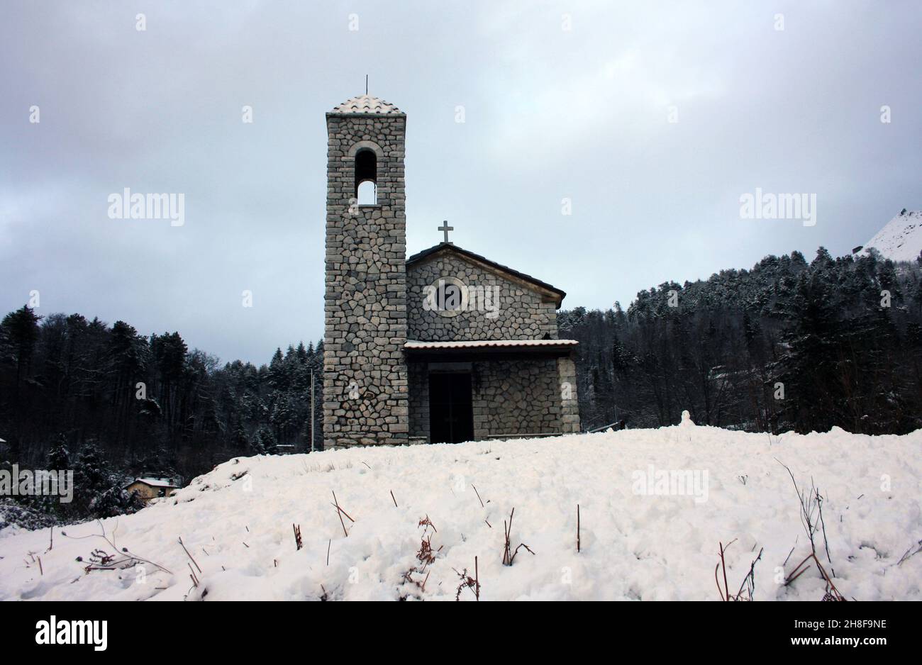 rustic provincial stone church in the cold of the white snow in the ...