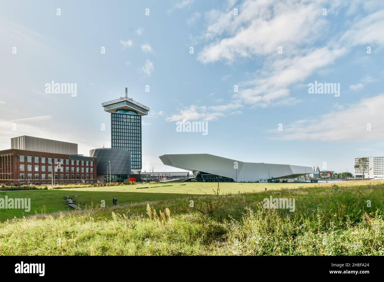 Large beautiful meadow with overgrown grass and unusual buildings in ...