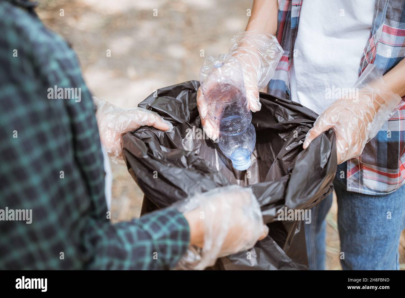 hand picking up plastic waste and put in the trash bag Stock Photo - Alamy
