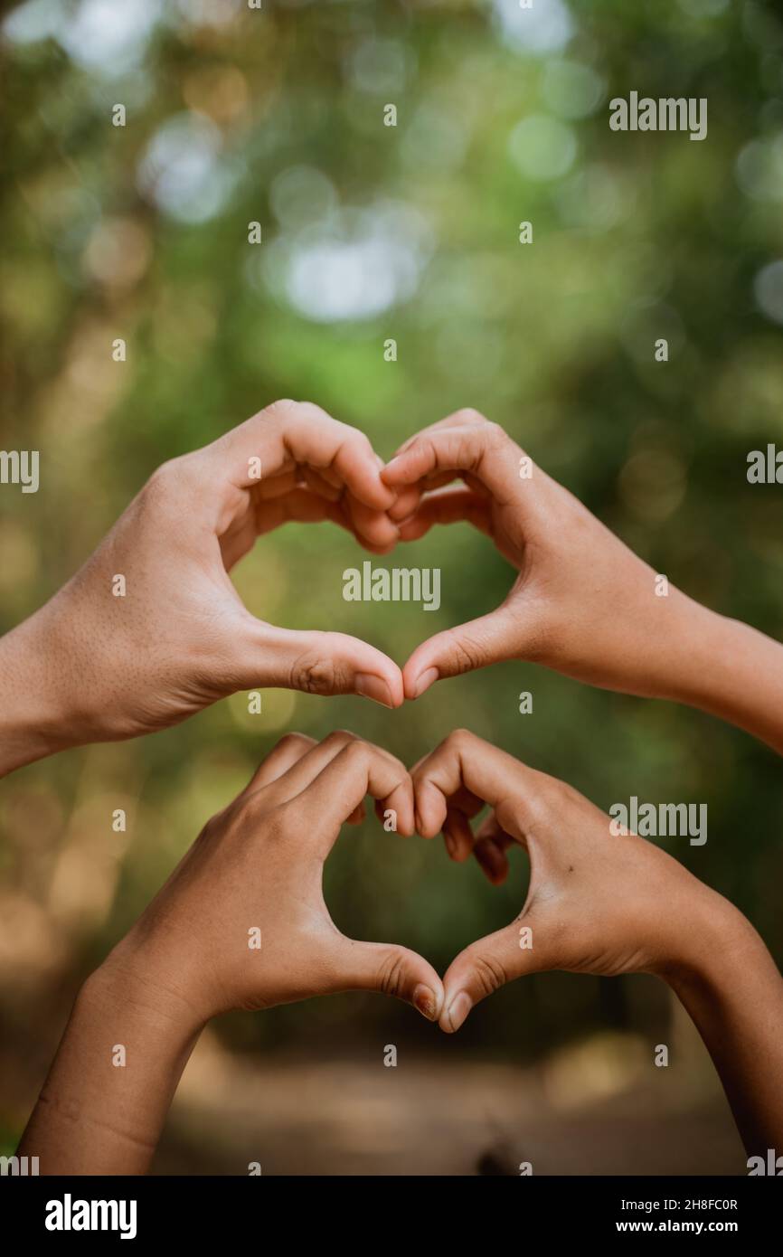 hand showing love with finger with blur background Stock Photo - Alamy