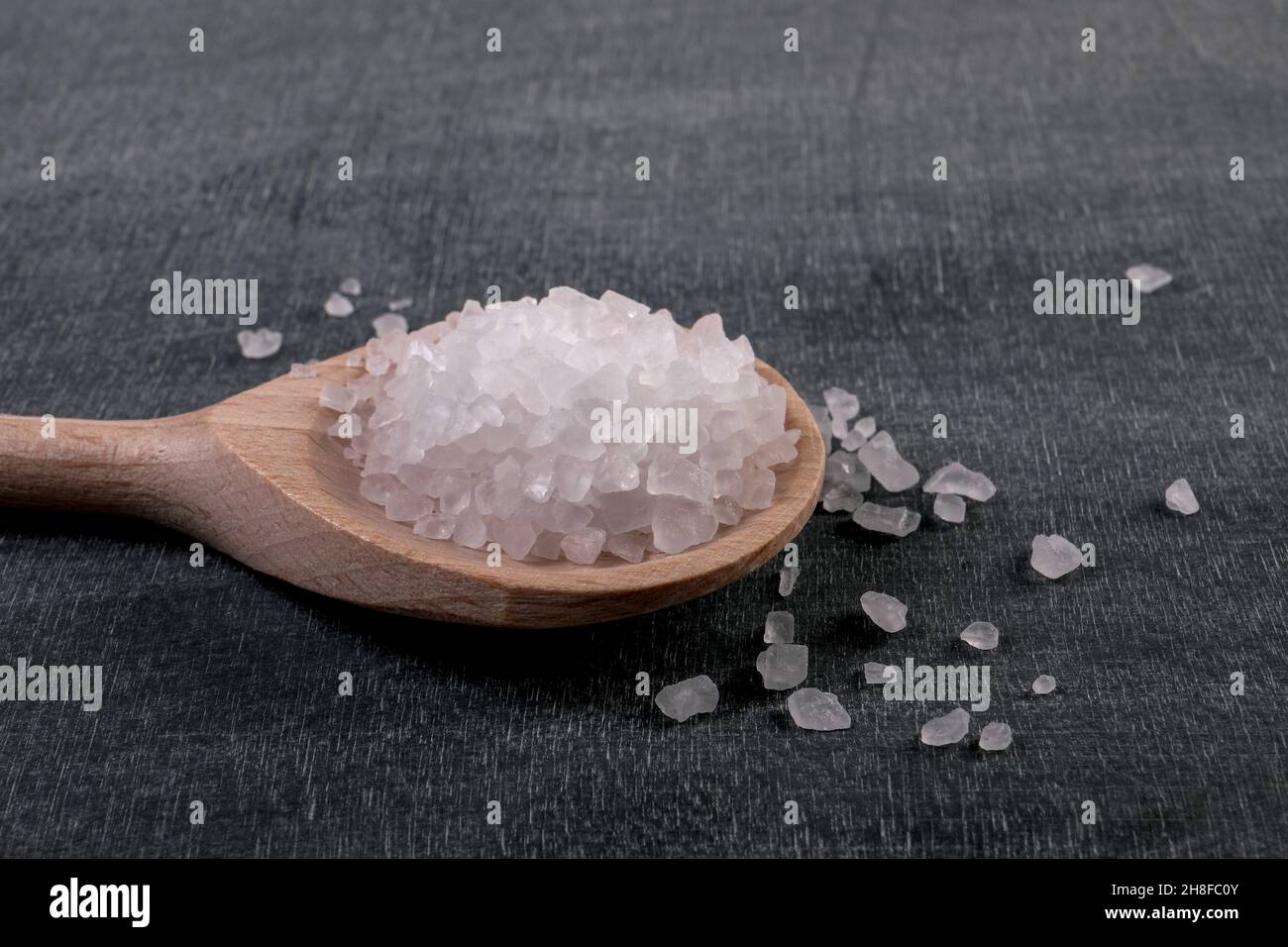 Pure white granular salt in a wooden spoon Stock Photo - Alamy