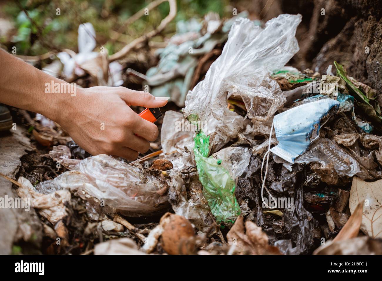 hand picking up plastic waste and put in the trash bag Stock Photo - Alamy