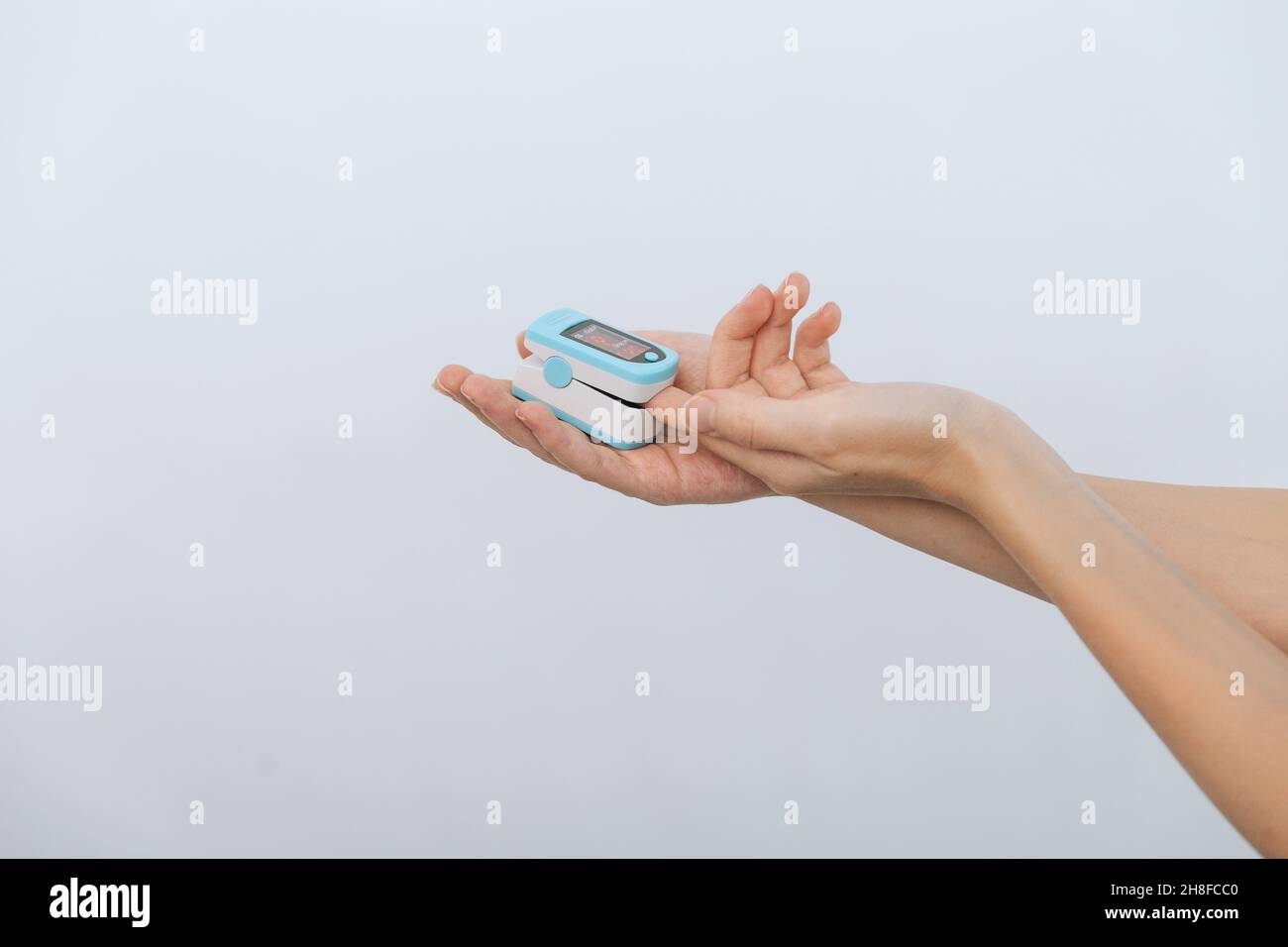 Pulse oximeter with hand of doctor isolated on white. The concept of ...
