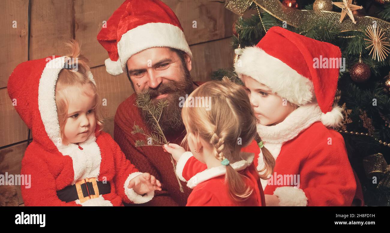Santa father with kids at Christmas tree. Christmas happy children and ...