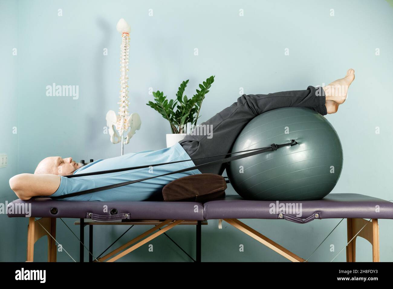 Rotation exercises on the fitness ball with resistance bands in ...