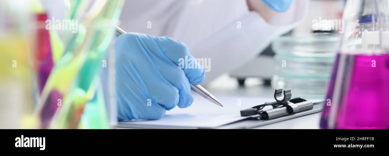 Researcher records data obtained from chemical experiment in laboratory ...