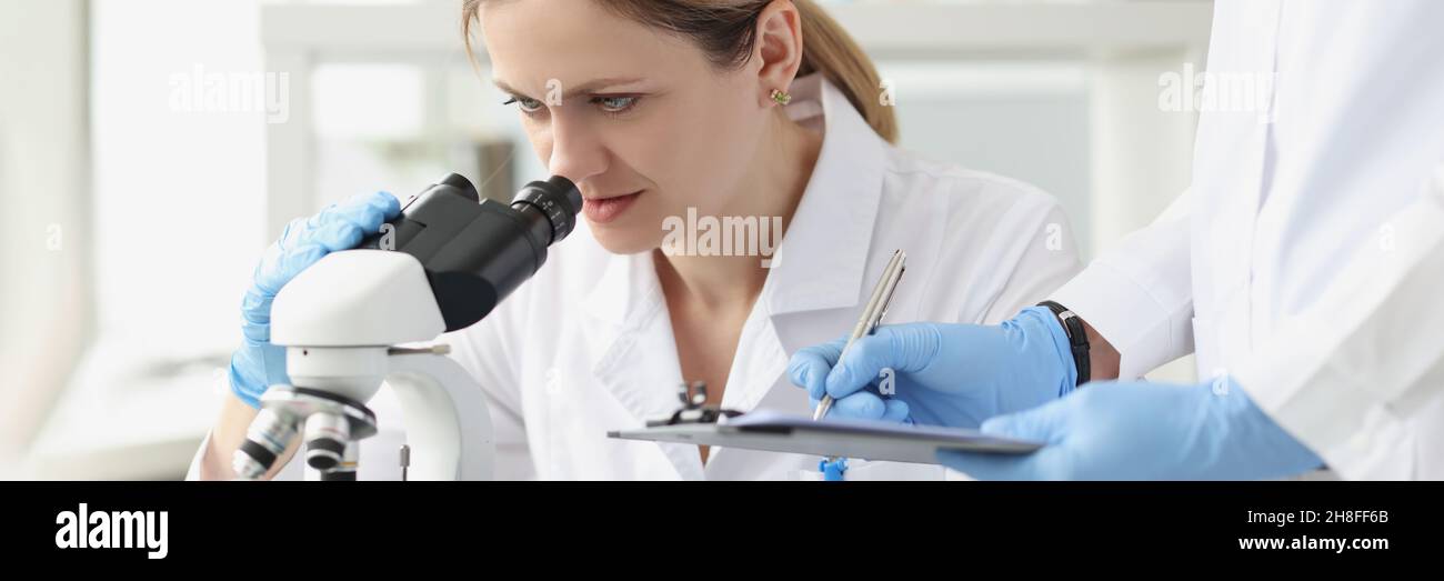 Team of scientists conducts laboratory research using microscope Stock ...