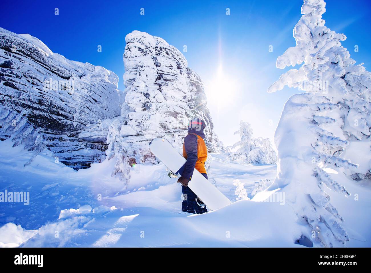 Snowboarder with snowboard background blue sky with sun light frozen ...
