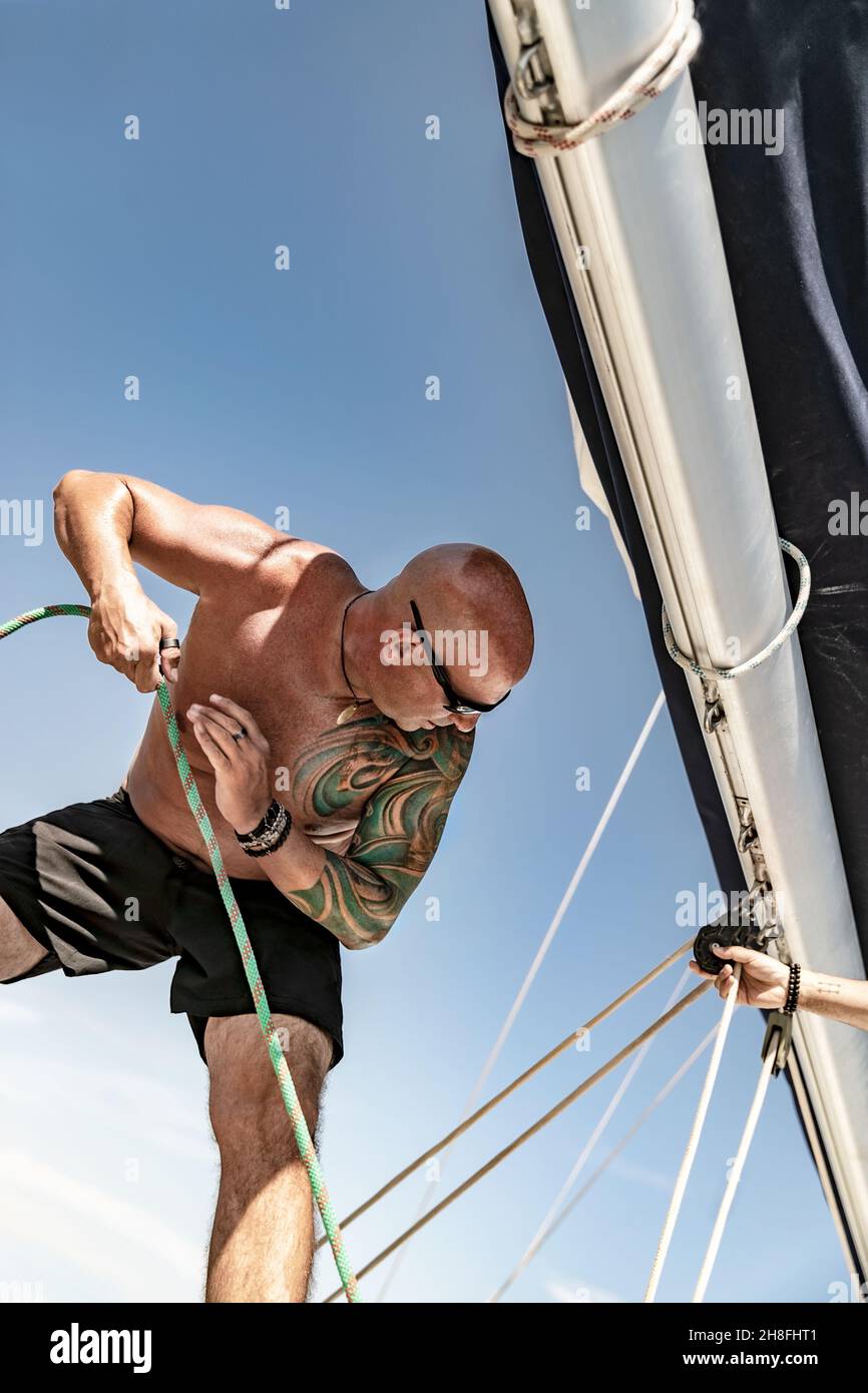 Portrait of a Handsome Man Working on Sailboat. Pulls the Rope. Summer ...