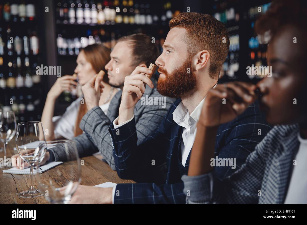 Young man listens to aroma of red wine at master class tasting in ...