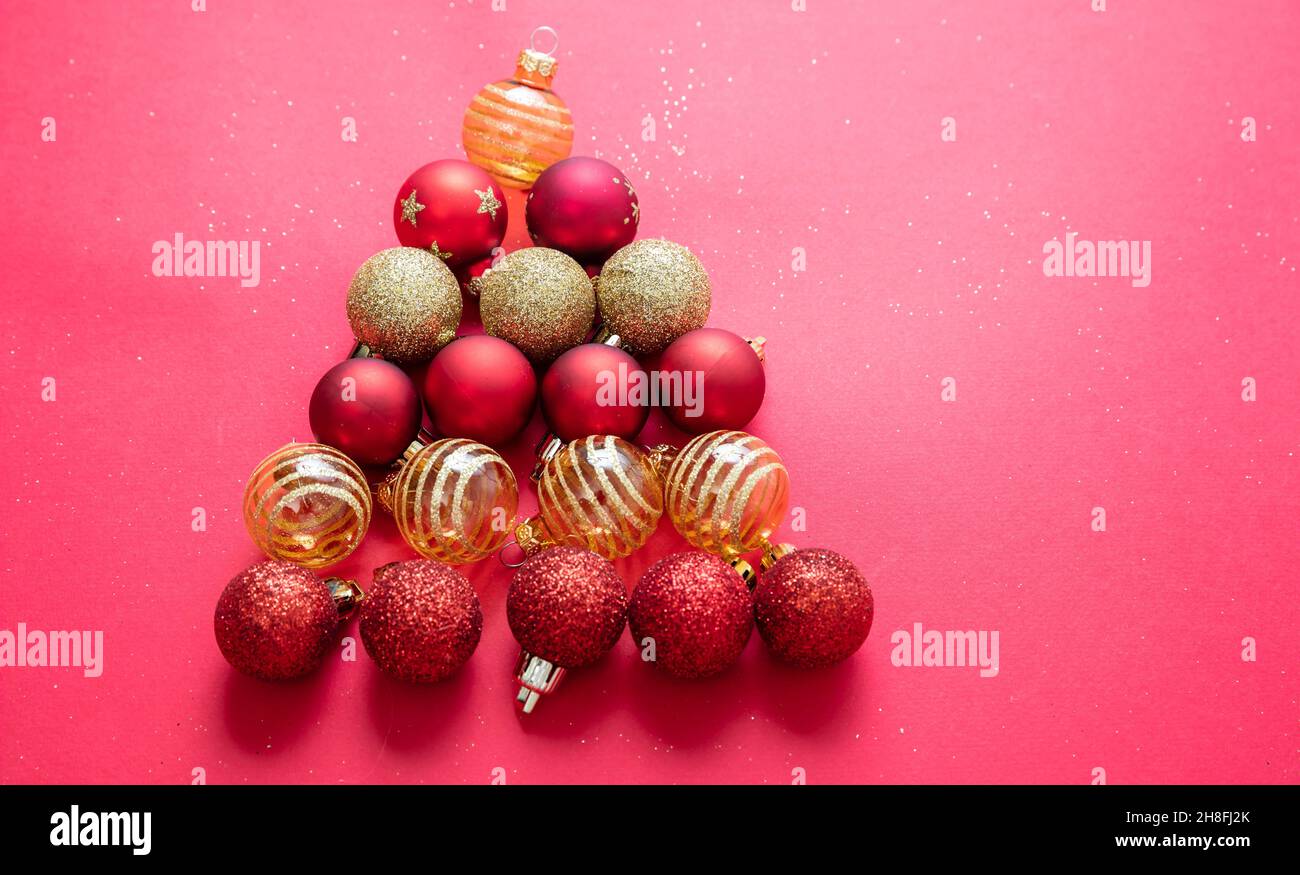 Christmas baubles in Xmas tree shape on red color background. Balls ...