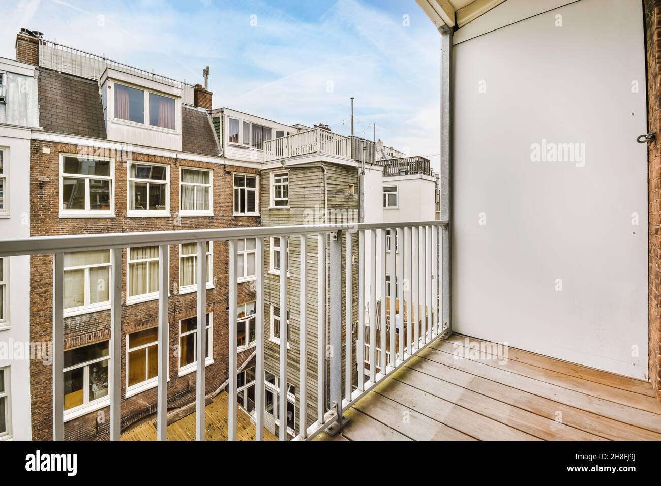 Pretty long narrow balcony with wooden white handrails Stock Photo - Alamy