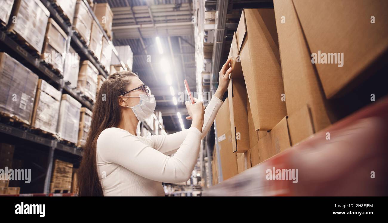 Point of postal, Woman warehouse worker in protective mask with phone ...