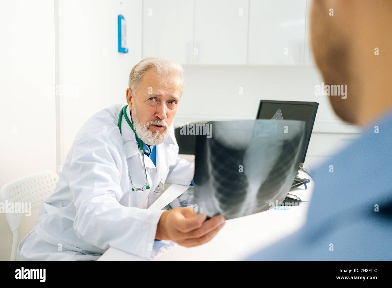 Close-up view from back of unrecognizable male patient listening mature ...