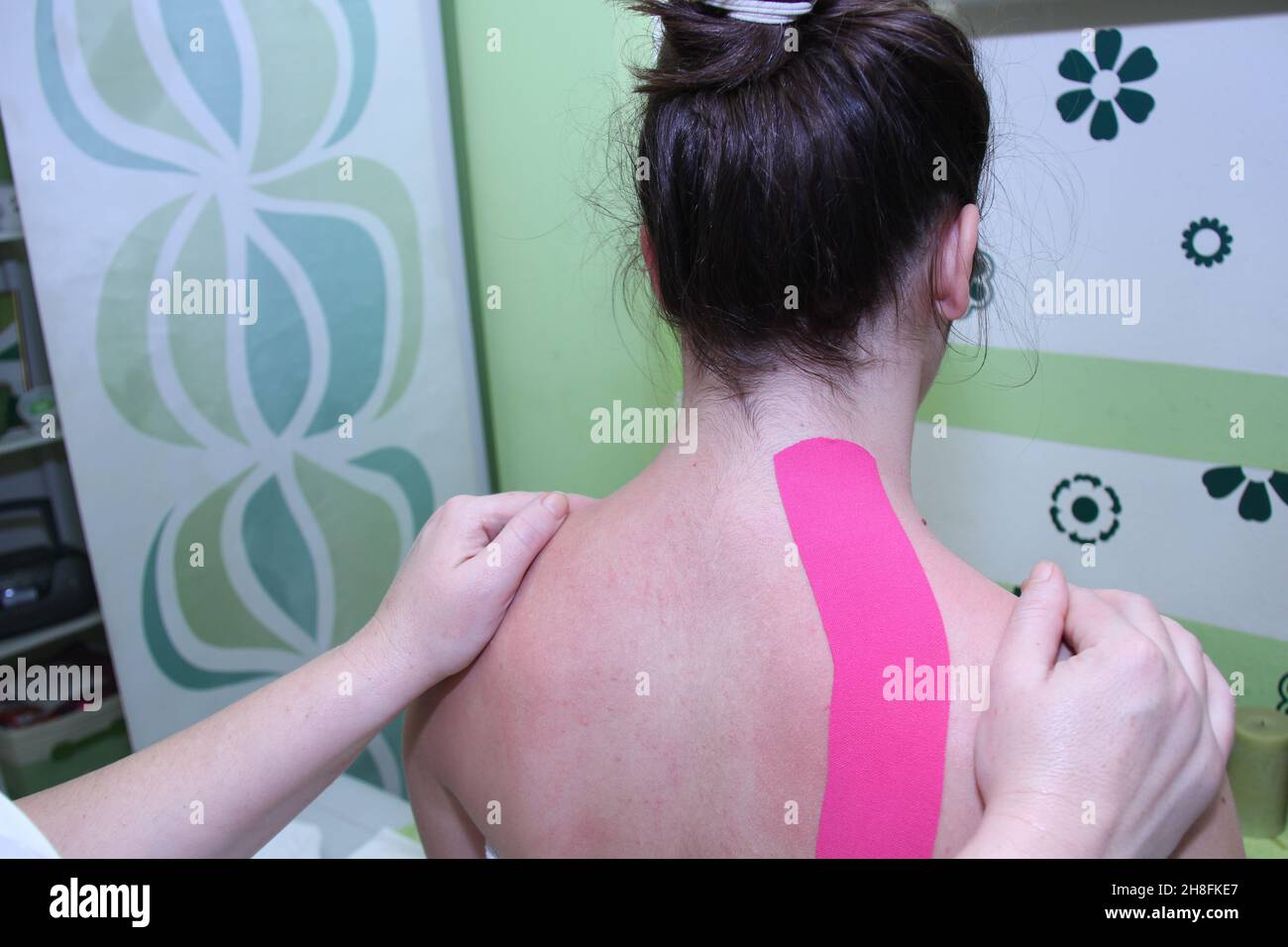 Kinesiology taping treatment with pink tape on female athlete patient ...