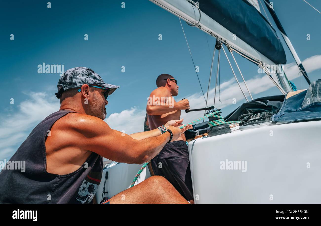 Handsome Strong Men Working on Sailboat. Pulls the Rope to Fold the ...