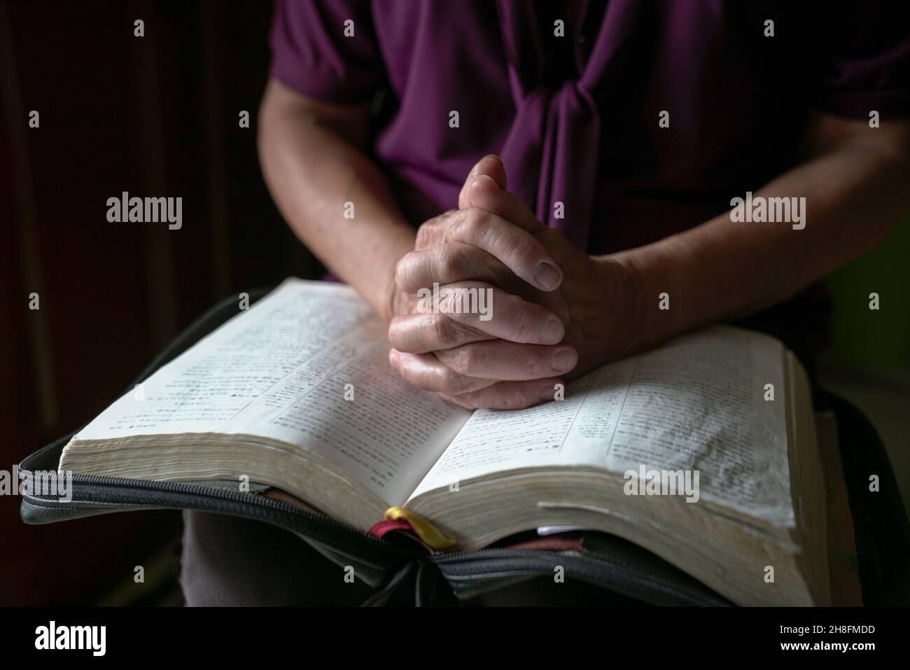 Praying hands on open bible hi-res stock photography and images - Alamy