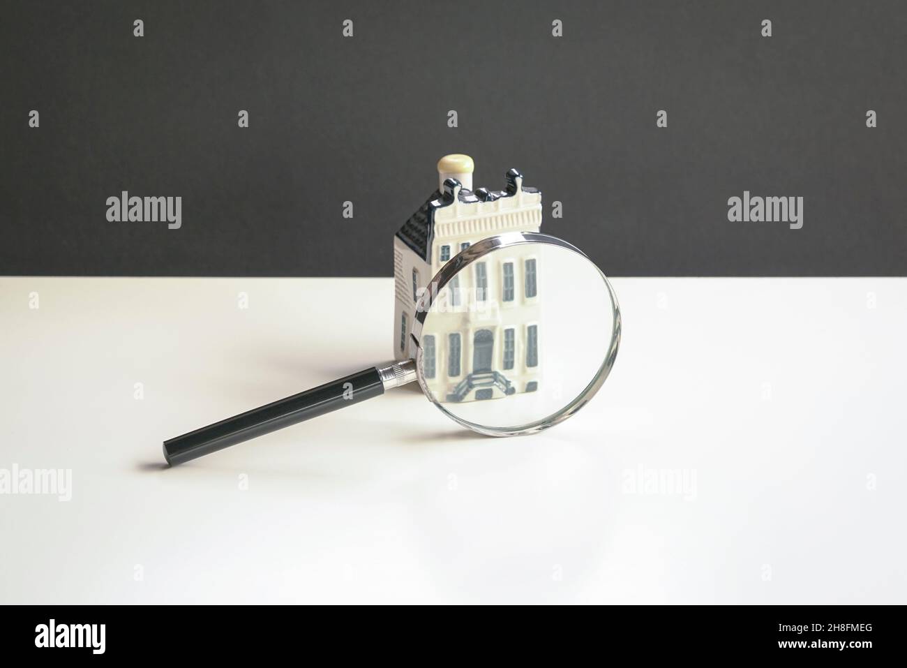 Magnifying glass on mini building, isolated. Search for property ...