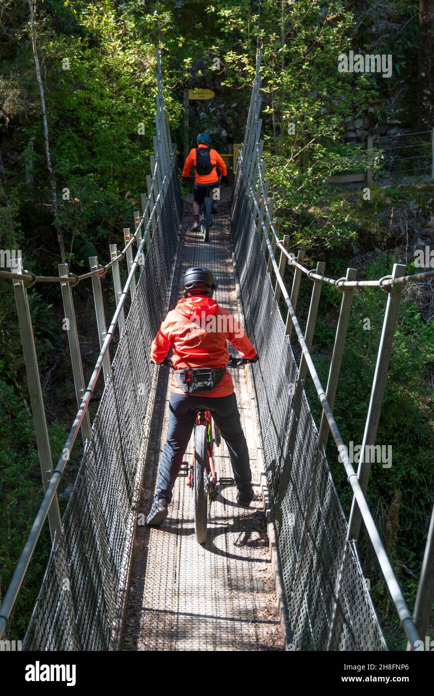 Cyclists on swing bridge, Old Ghost Road, cycle trail, Lyell, Buller ...