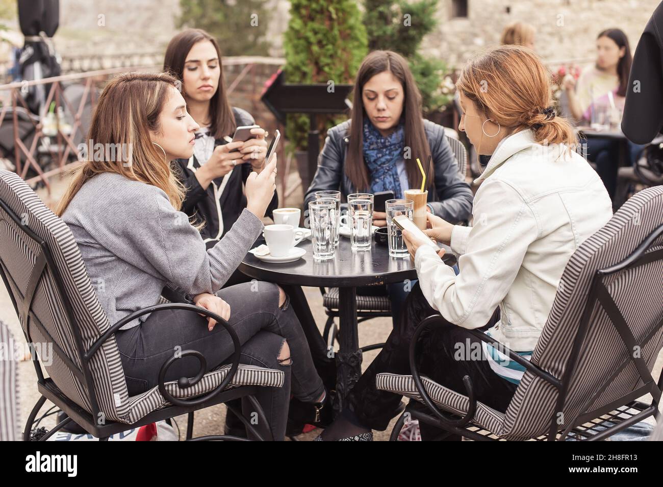 Four woman in cafe using app smartphone playing social network ...
