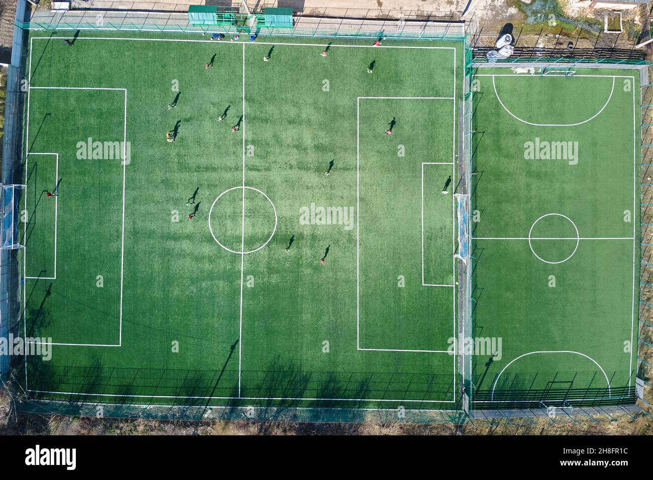 Aerial view of soccer players playing football on green sports stadium ...