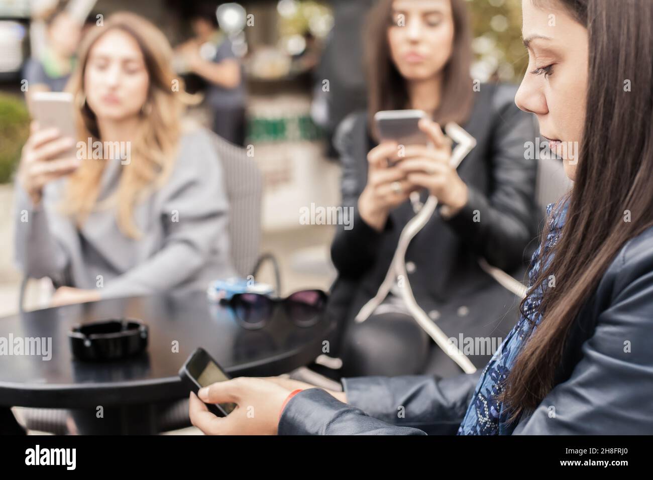 Three woman in cafe using app smartphone playing social network ...