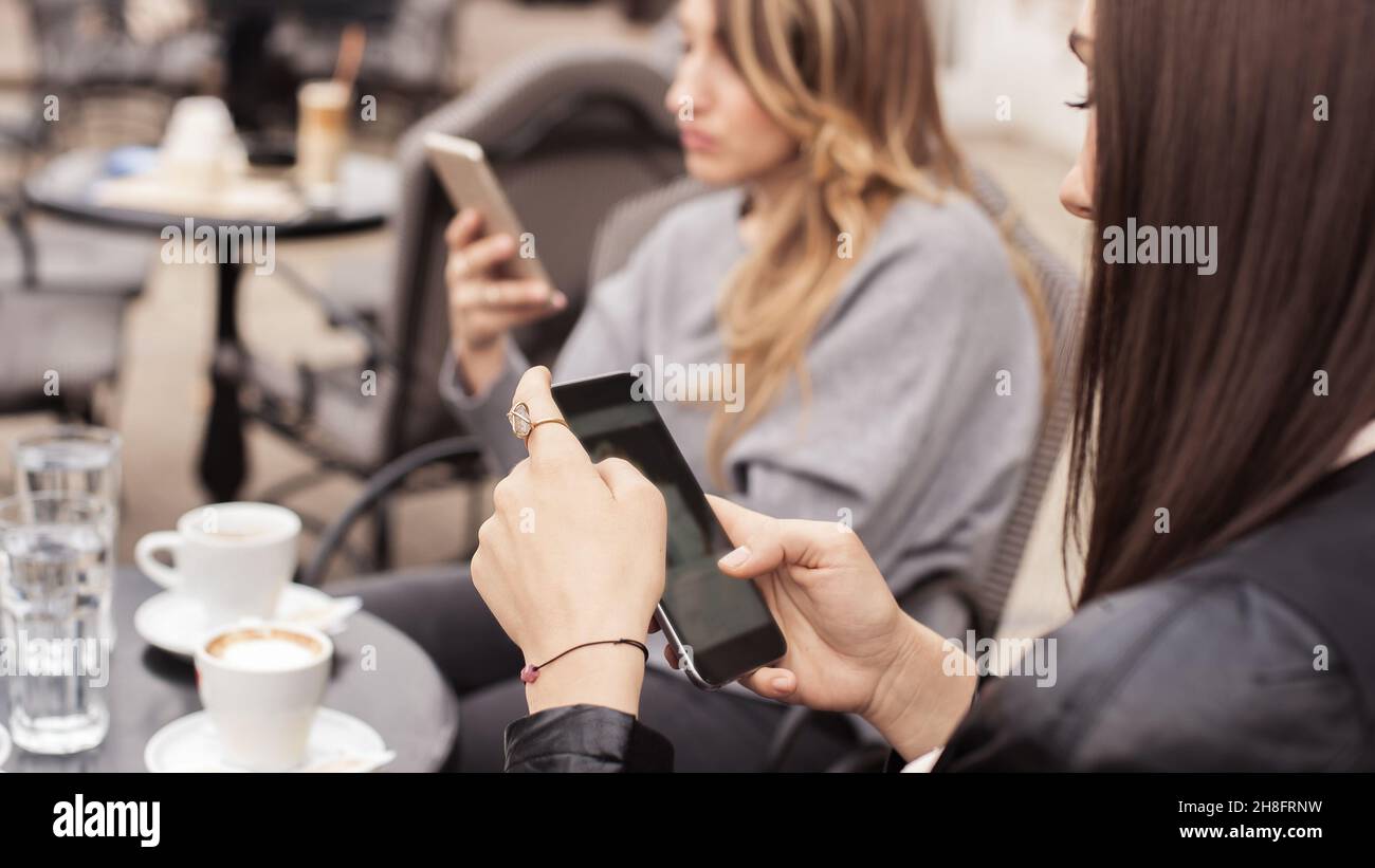 Two woman in cafe using app smartphone playing social network ...
