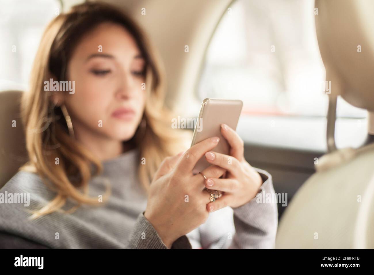 Young girl uses a mobile phone in the car. Technology cell phone ...