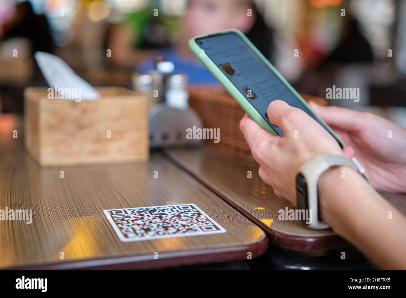 Closeup of guest hand ordering meal in restaurant while scanning qr ...