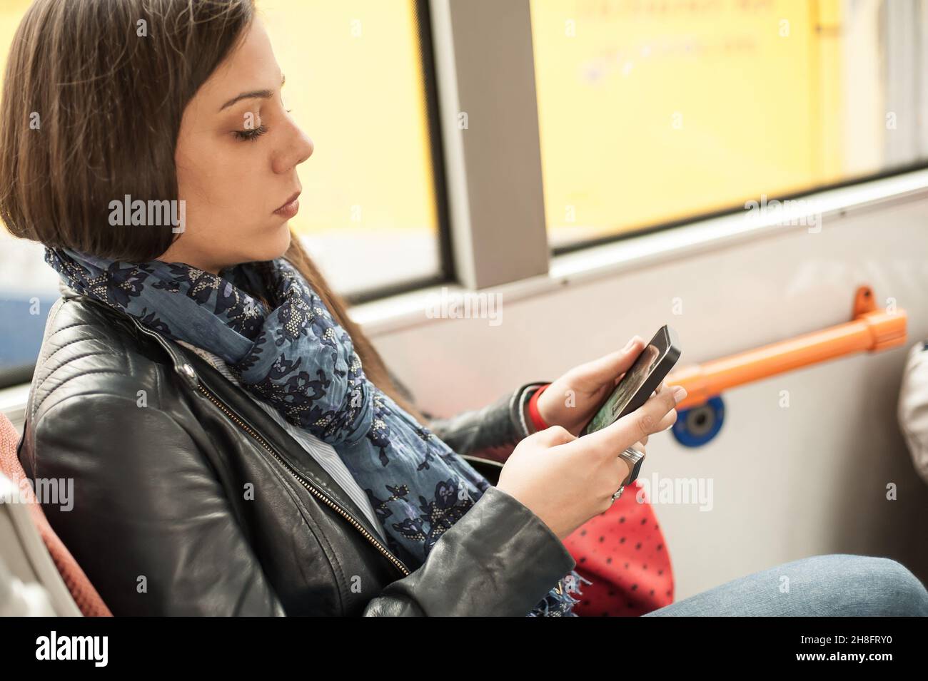 Young girl uses a mobile phone in the city bus. Technology cell phone ...