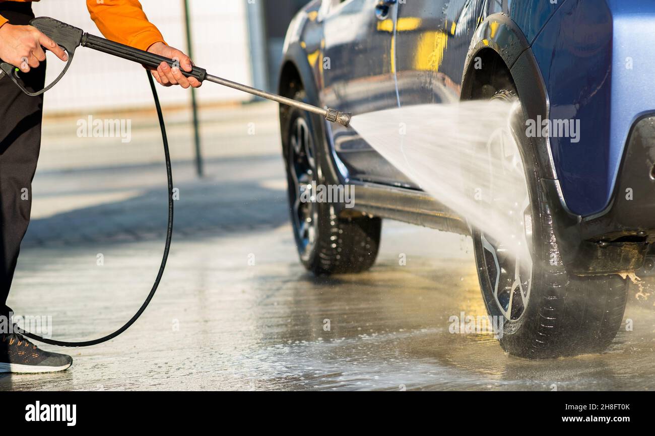 Closeup of male driver washing his car with contactless high pressure ...