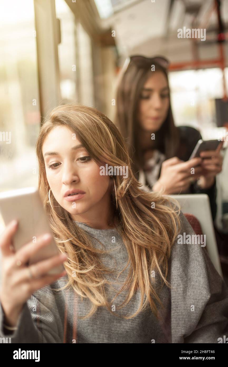 Young girl uses a mobile phone in the city bus. Technology cell phone ...