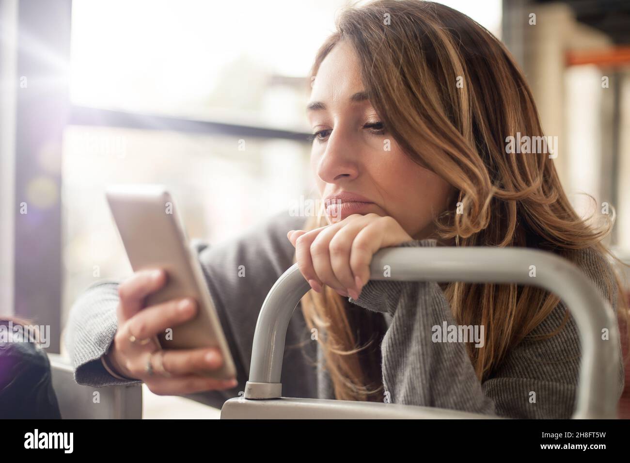 Young girl uses a mobile phone in the city bus. Technology cell phone ...