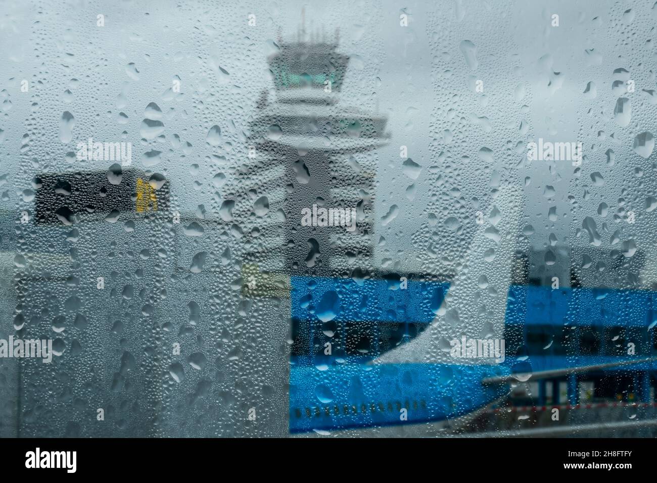 Rainy weather in a modern airport. Parked plane. View through a window ...